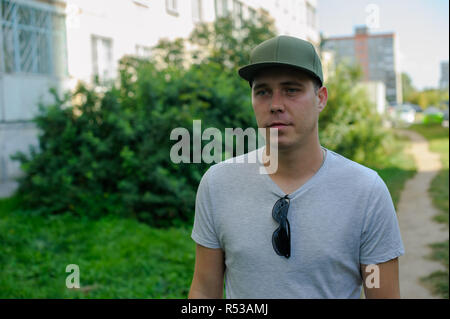 young guy standard physique posing on the street on a background of ...