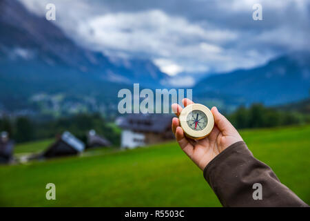 Explorer searching direction with compass in the hand Stock Photo - Alamy