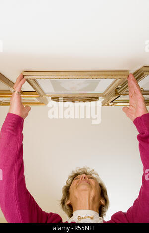 Woman adjusting picture frames Stock Photo - Alamy