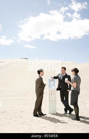 People around water cooler in the desert Stock Photo - Alamy
