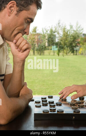 Man moving chess pieces at checkerboard, closeup Stock Photo - Alamy