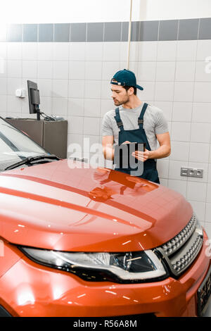 auto mechanic with notepad examining car at auto repair shop Stock ...