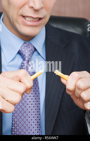 Furious angry businessman breaking a pencil - isolated on white ...