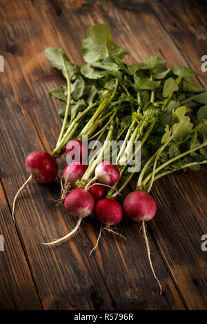 Ripe bunch red radish with foliage on a black slate dish as background ...