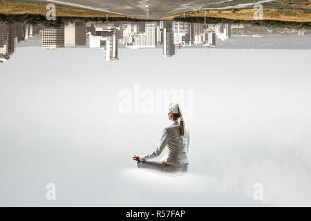 Beautiful businesswoman meditating . Mixed media Stock Photo - Alamy