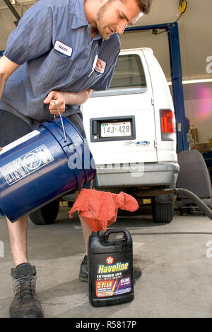 Car mechanic changes oil in a workshop Stock Photo - Alamy