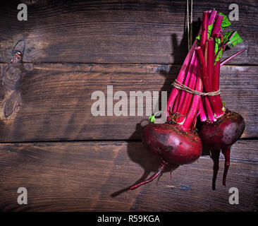 Two fresh red beets hang on a rope on a wooden wall Stock Photo - Alamy