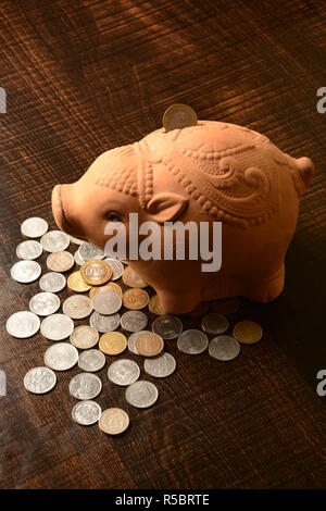 Money-saving bank, Gold Gullak gulak coin box in between of many black ...