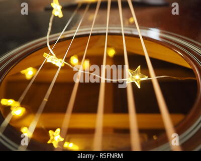Star light string hanging on strings of a acoustic guitar Stock Photo ...