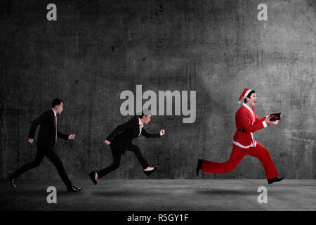 Business people chasing santa claus Stock Photo - Alamy