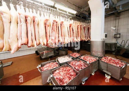 The meat factory. Pork hanging on hooks. Pork carcasses in the workshop ...