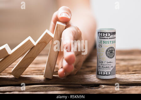 Businesswoman Hand Stopping Wooden Blocks From Falling On Desk At ...