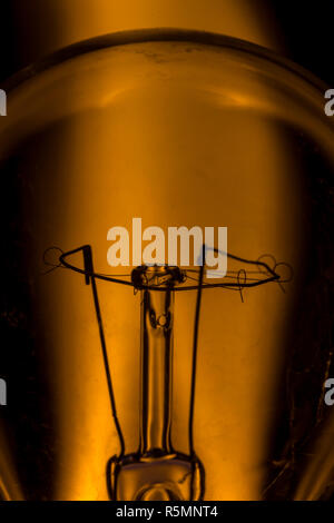 Tungsten light bulb burning like a candle isolated on black background ...