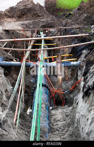 Laying a fiber optic and electricity cables in the frozen ground ...