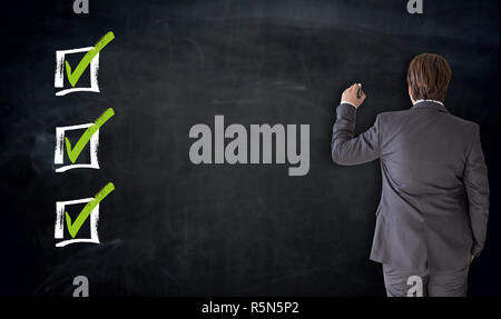 Businessman writing checkbox on blackboard concept Stock Photo - Alamy
