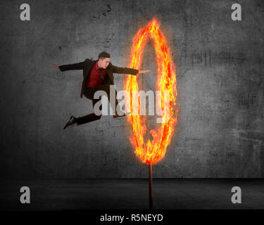 A man is jumping through a ring of fire during the display of the ...