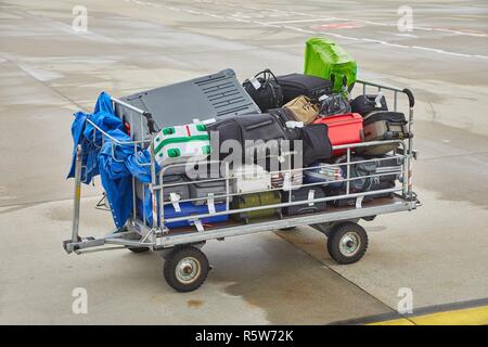 Airport baggage cart with an enormous pile of luggage on it, stacked ...