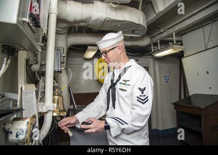 US Navy A watch stander conducts evening colors aboard the newly ...