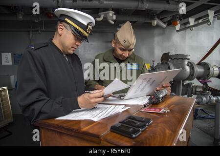 US Navy A watch stander conducts evening colors aboard the newly ...