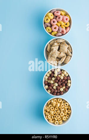 top view of various kids cereals in colorful bowls on wooden table ...