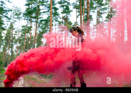 Woman holding colorful smoke grenade outdoors in city. Urban ...