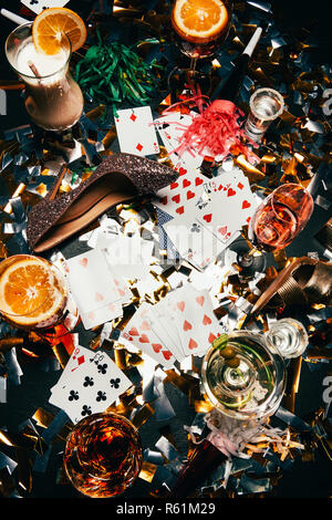 elevated view of playing cards, alcoholic cocktails with orange slices ...