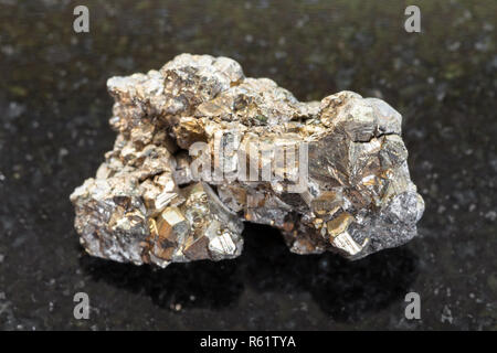 A specimen of a rough pyrites rock with a dark background Stock Photo ...