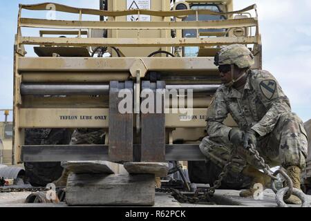 A U.S. Army Soldier with the 96th Transportation Company loads a ...