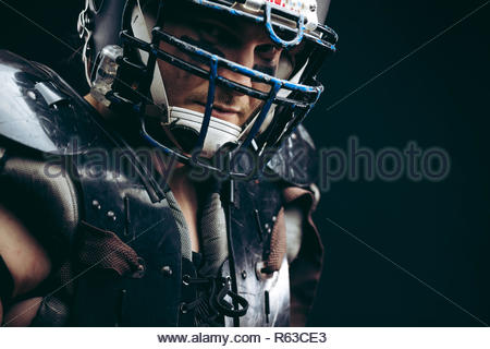 Football player wearing protective gear and holding helmet Stock Photo ...