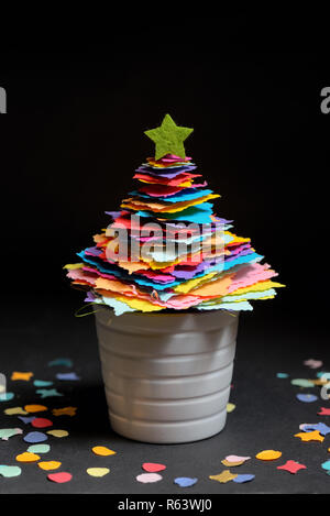 Small paper cut Christmas tree inserted into the slot on blue ...