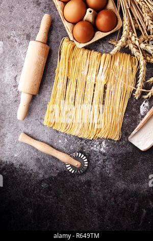 Fresh homemade pasta with pasta ingredients on the dark wooden table ...