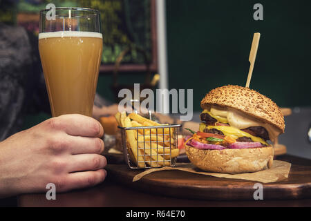 Man eating burgers at table, pov view Stock Photo - Alamy