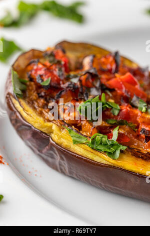 Imam Bayildi. Eggplants stuffed with vegetables on white plate. Turkish ...