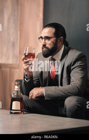 Businessman wearing red tie drinking glass of whisky Stock Photo - Alamy