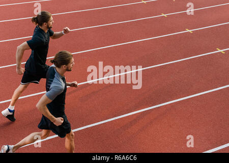 Image of young two twins sportsmen brothers running at the stadium ...