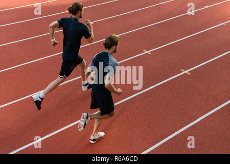 Image of young two twins sportsmen brothers running at the stadium ...