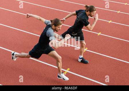 Image of young two twins sportsmen brothers running at the stadium ...