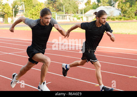 Image of young two twins sportsmen brothers running at the stadium ...