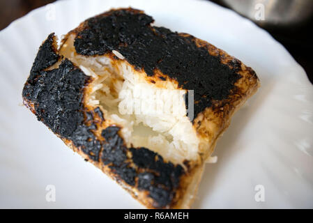 Completely burnt rice on plate next to pot standing on table in kitchen ...