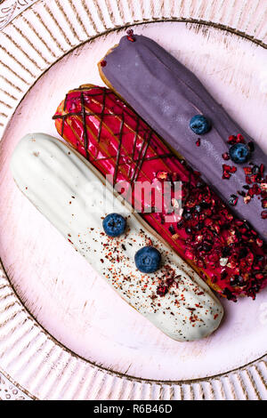 red raspberry and white with blueberry eclairs on white plate Stock ...