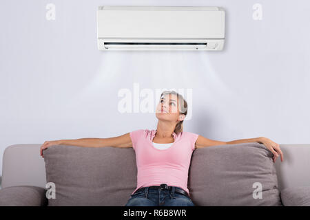 Woman Relaxing Under The Air Conditioner Stock Photo - Alamy