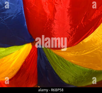 colorful game parachute made of thin silk attached to the ceiling ...