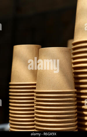 Close up stack of brown disposable kraft paper cups on coffee machine ...