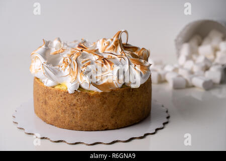 Lemon meringue cheesecake on white plate on white background Stock ...