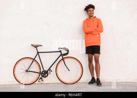 Image of a young happy cheerful sports guy outdoors on the beach with ...