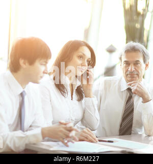 business colleagues analyzing financial statistics sitting at a Desk ...