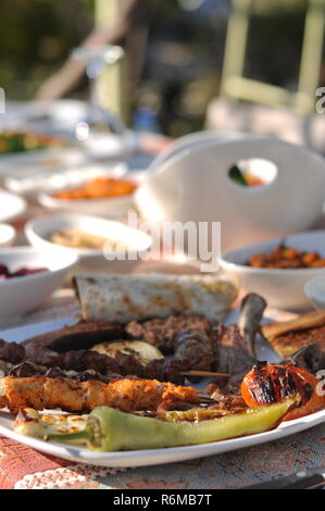 Traditional Cypriot meze and kebap barbecue party in the garden with ...