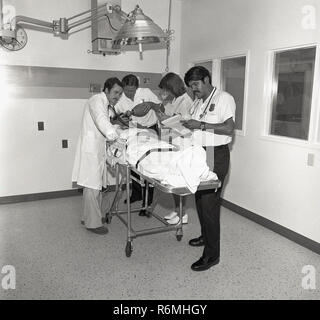 1970s, female patient on a hospital trolley being given oxygen and with ...
