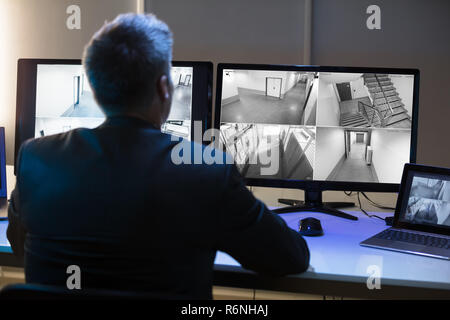 Businessman Looking At CCTV Camera Footage Stock Photo - Alamy