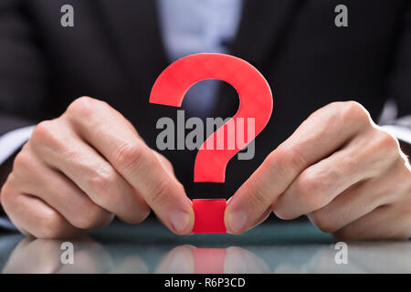 Businessperson Holding Question Mark Sign Stock Photo - Alamy